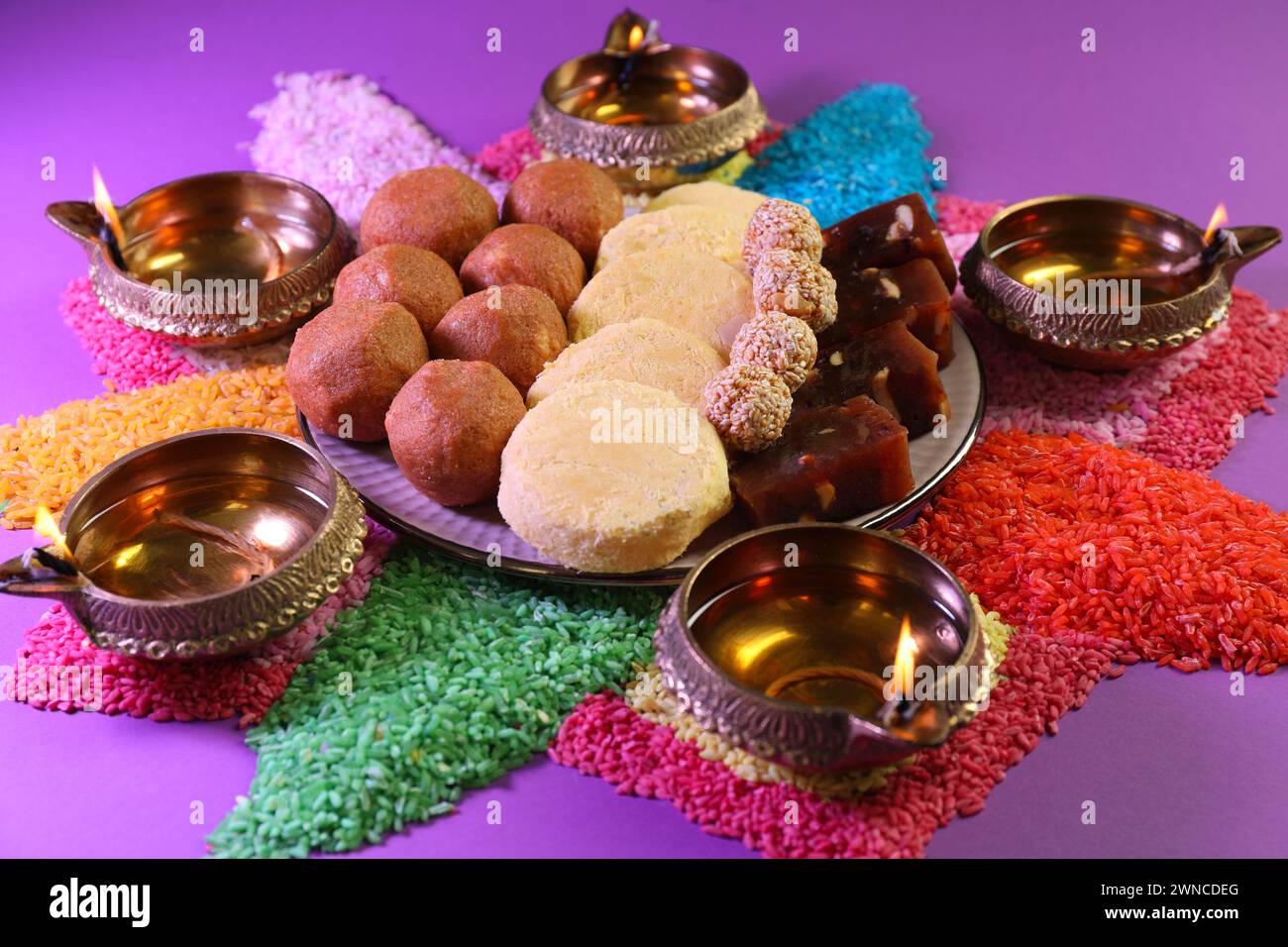 Diwali celebration. Tasty Indian sweets, diya lamps and colorful ...