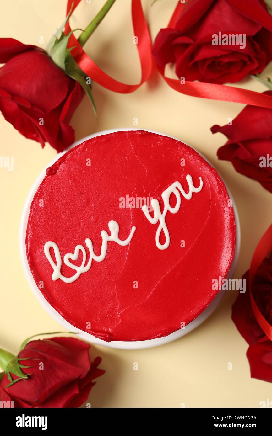 Bento cake with text Love You and red roses on beige table, top view ...