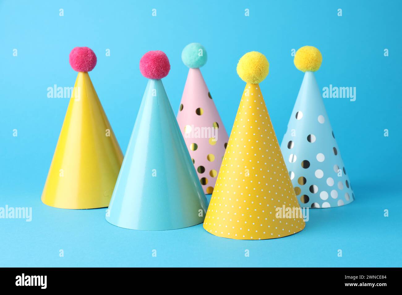 Colorful party hats on light blue background Stock Photo - Alamy