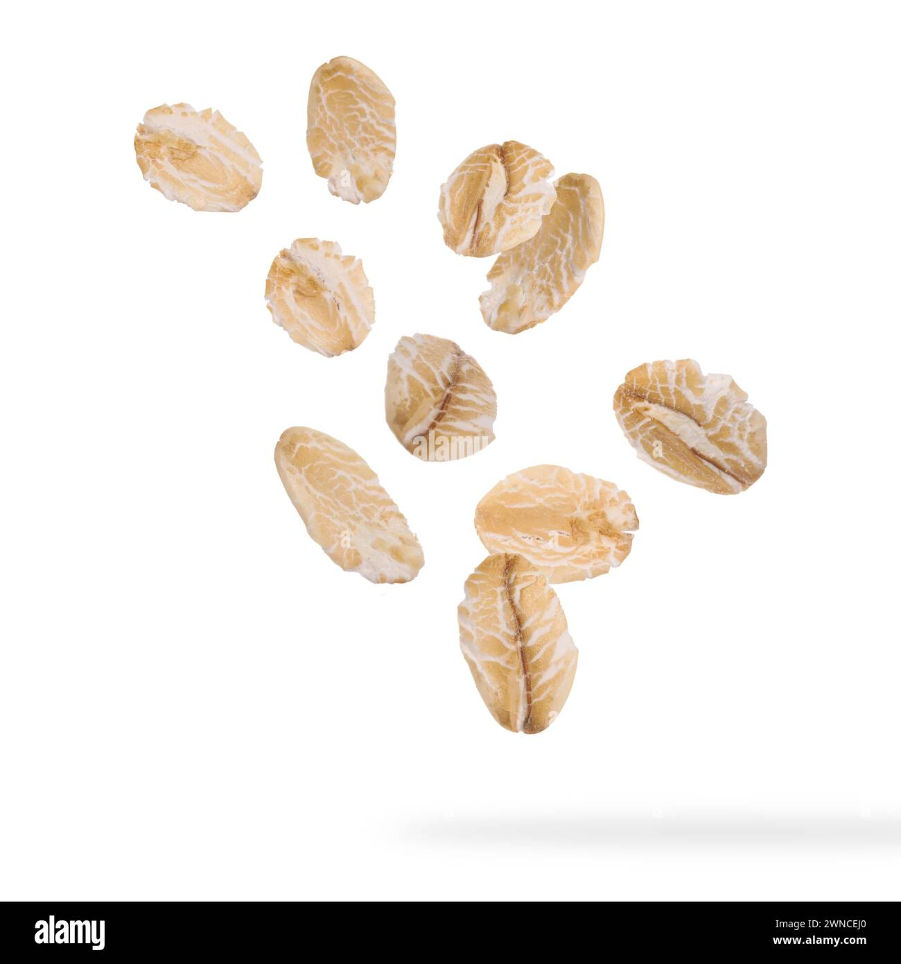 Rolled oat flakes falling on white background Stock Photo - Alamy