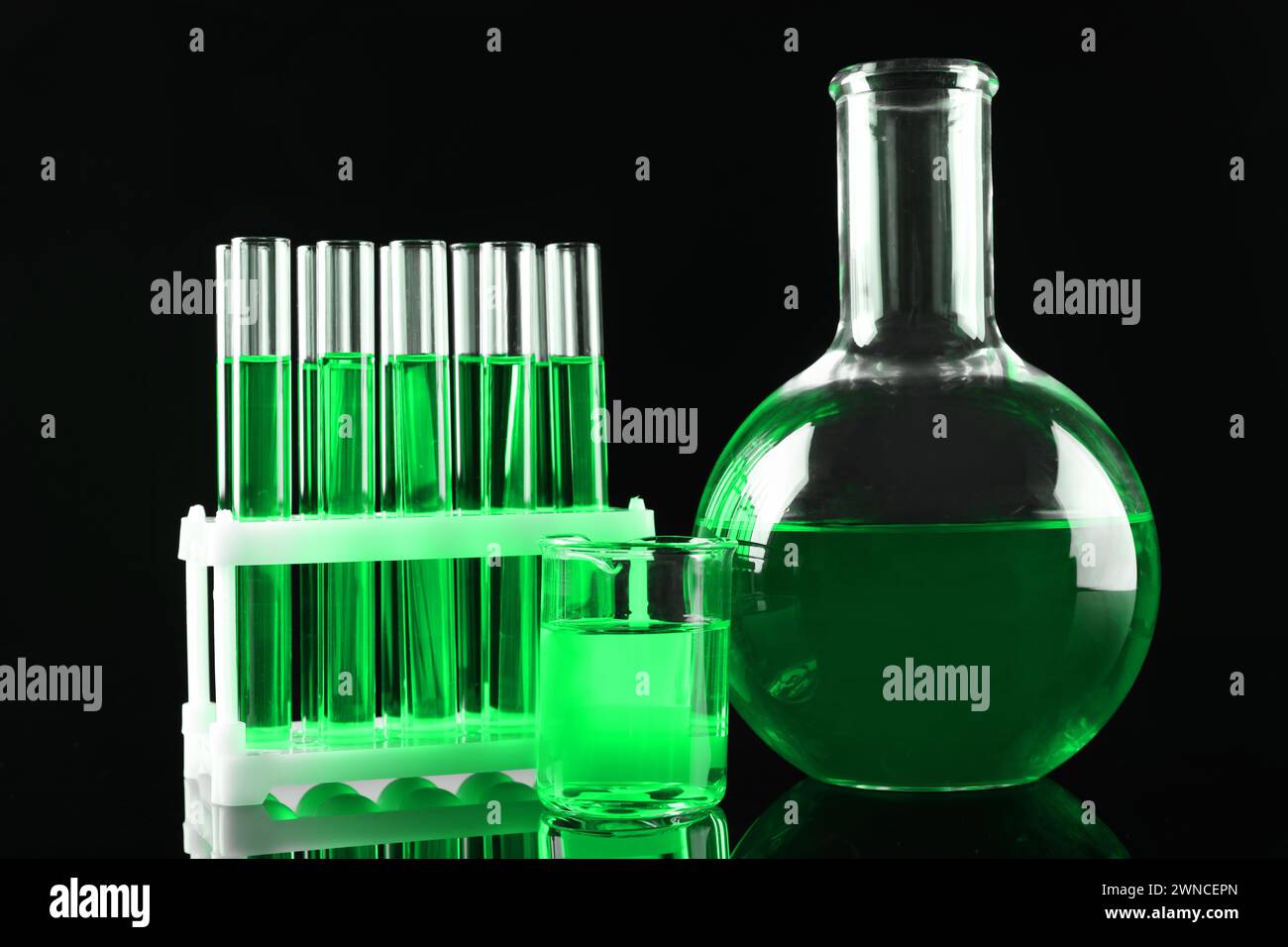 Laboratory glassware with green liquid on black background Stock Photo ...