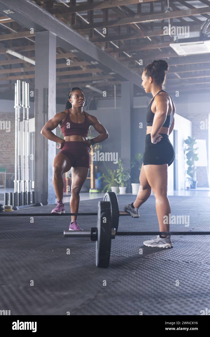 Two strong, fit biracial women are engaged in a workout session at a ...