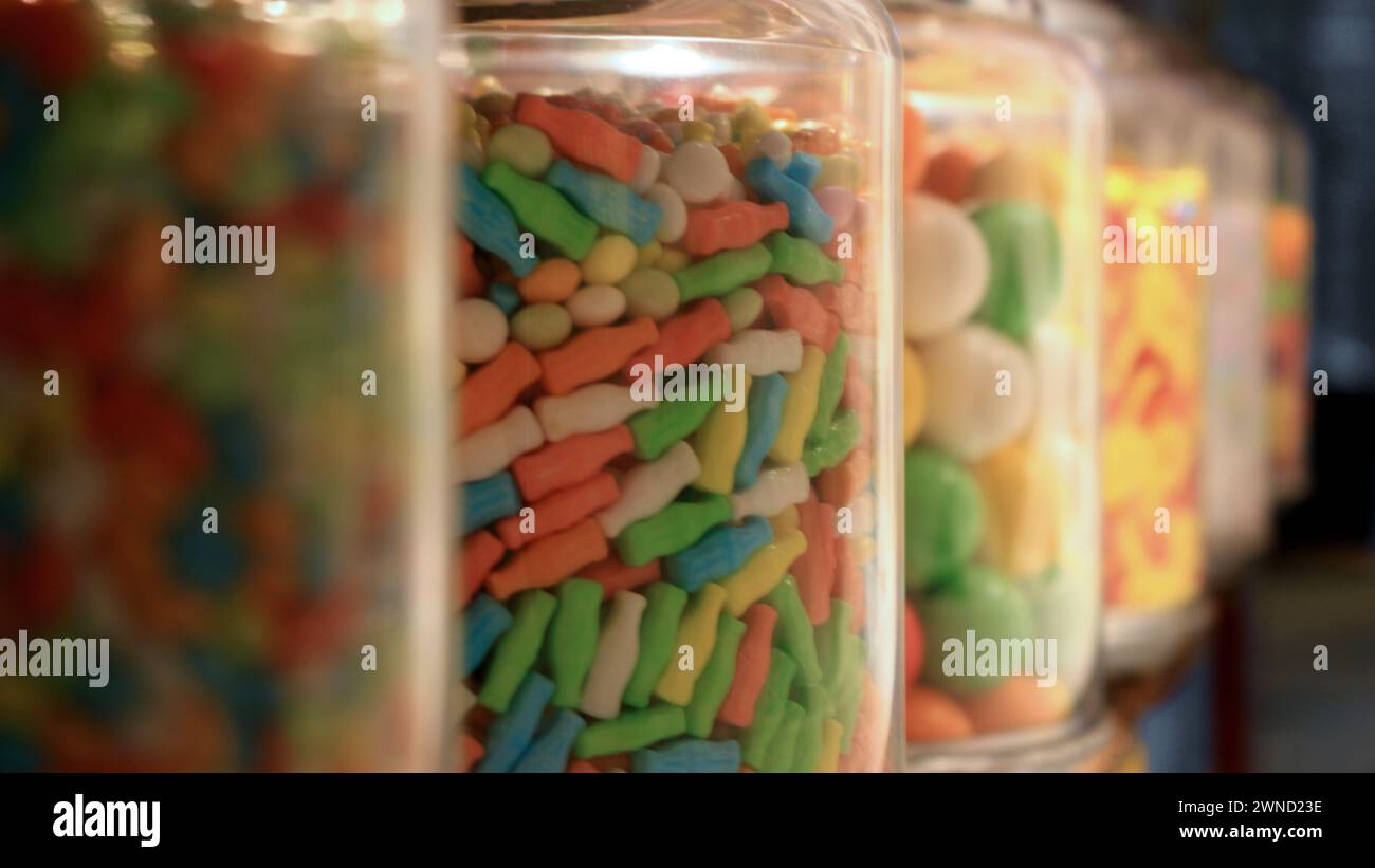 A close-up defocus photo of a jar filled with colorful sweets that look ...