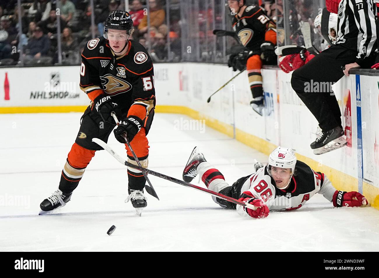 New Jersey Devils center Jack Hughes, right, reaches for the puck as ...