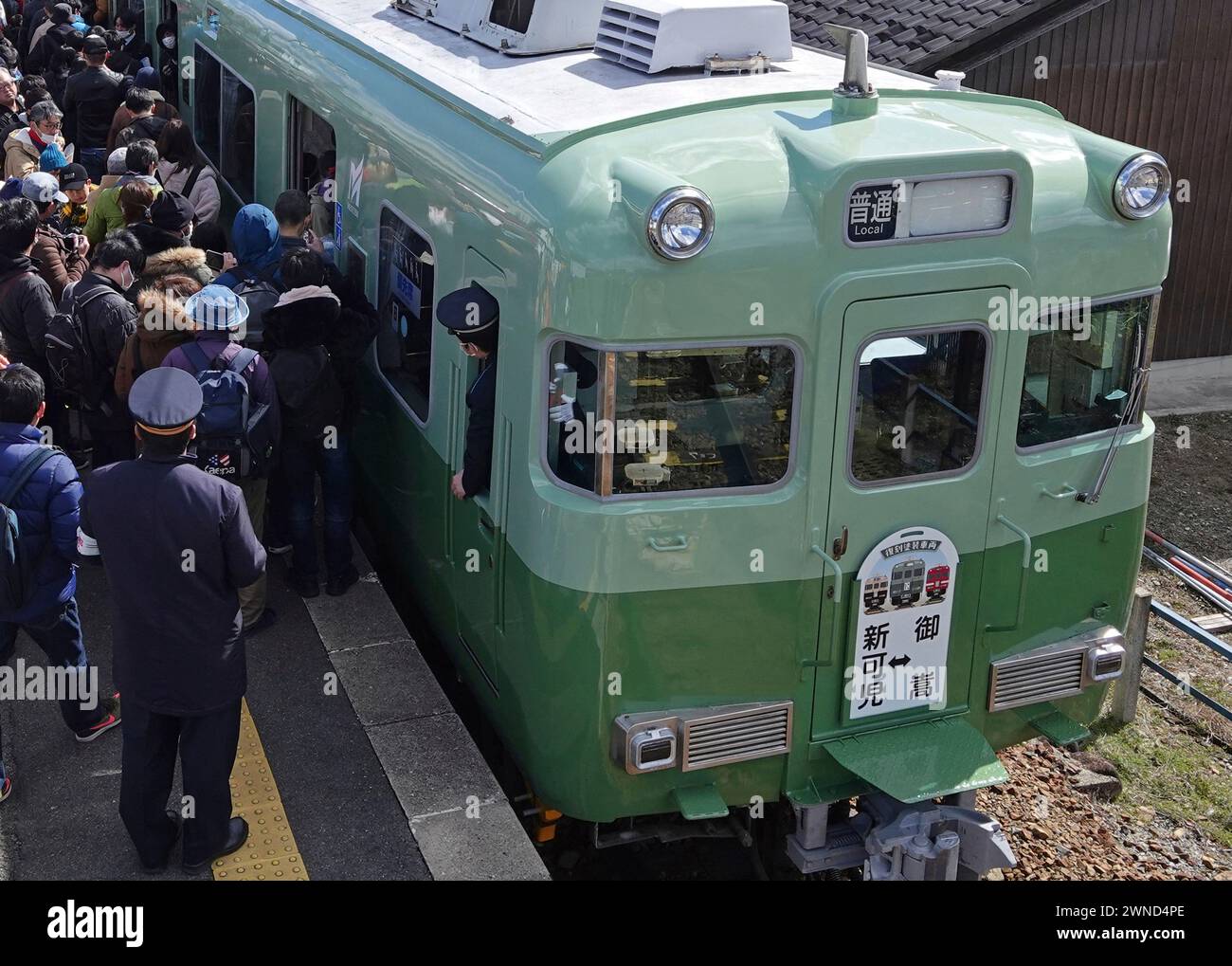Trainspotters crowd the Mitake Station to see a reprint painting train ...