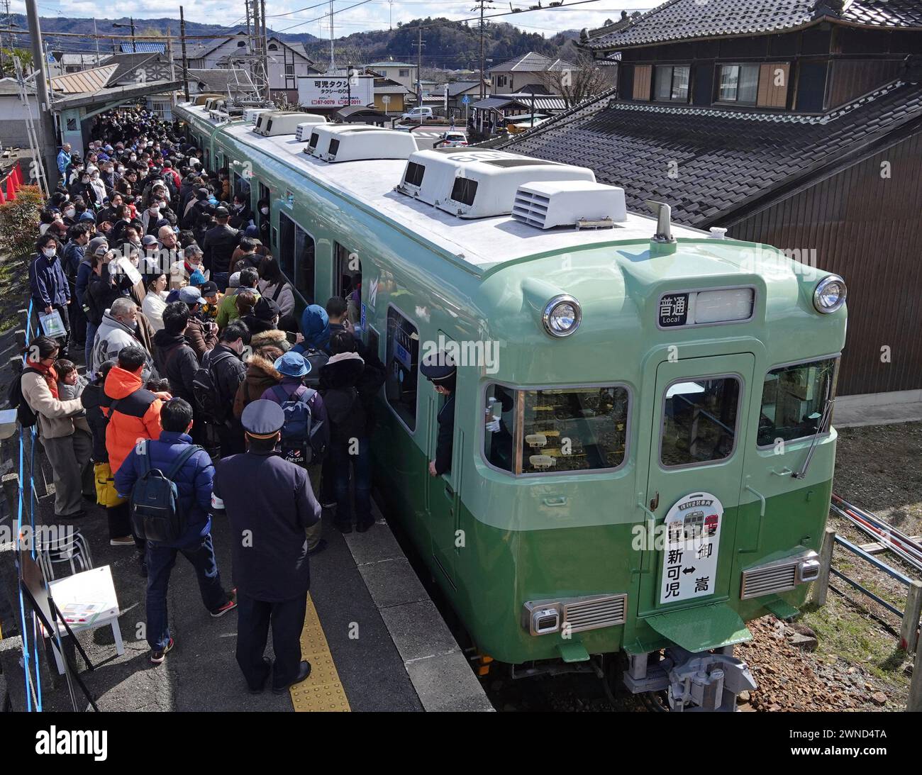 Trainspotters crowd the Mitake Station to see a reprint painting train ...