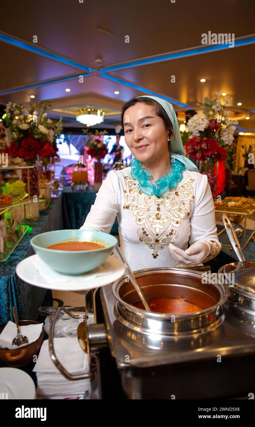 A joyful Uzbek woman in ethnic attire and ornate accessories happily ...