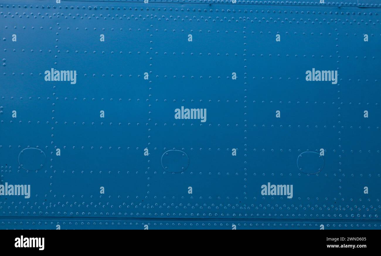 Blue metal surface of the aircraft fuselage with rivets. Aircraft skin ...