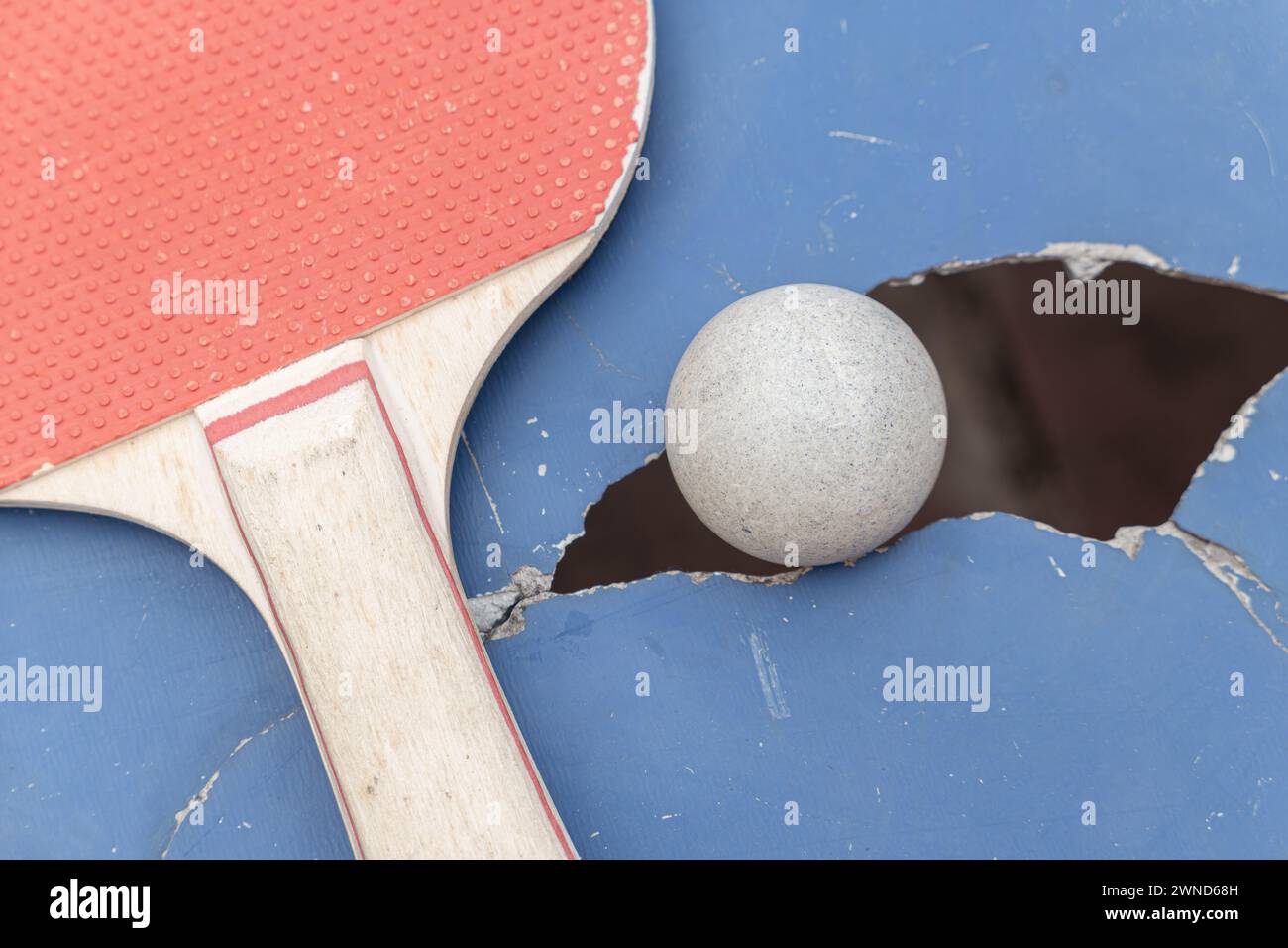 pingpong ball and racket on a damaged table at horizontal composition ...