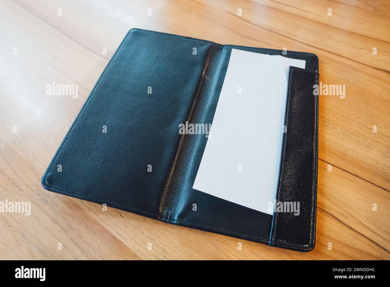 Blank empty white paper in black leather restaurant payment billing ...