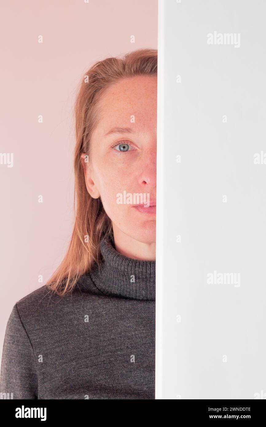 Portrait of an adult blonde woman with gray eyes. Half of the face is ...