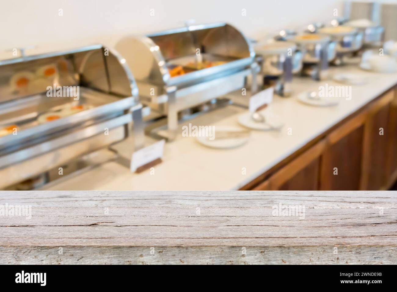 wood table with Many buffet heated trays in the hotel restaurant blur ...