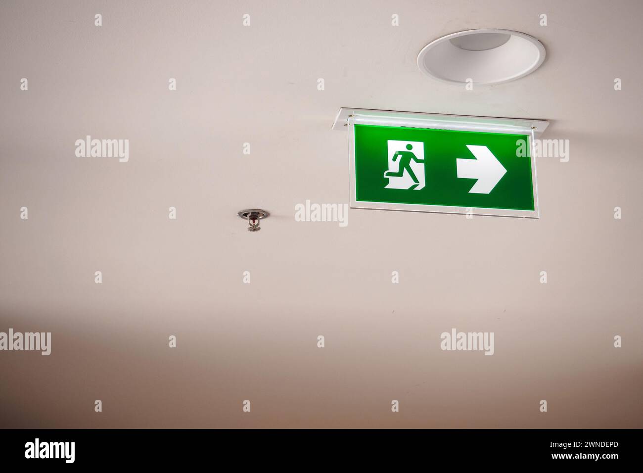 emergency fire exit sign and fire sprinkler in large building Stock ...