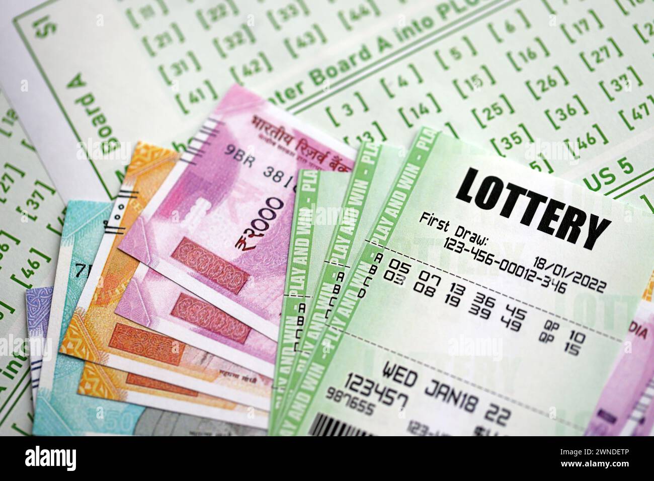 Green lottery tickets and indian rupees money bills on blank with ...