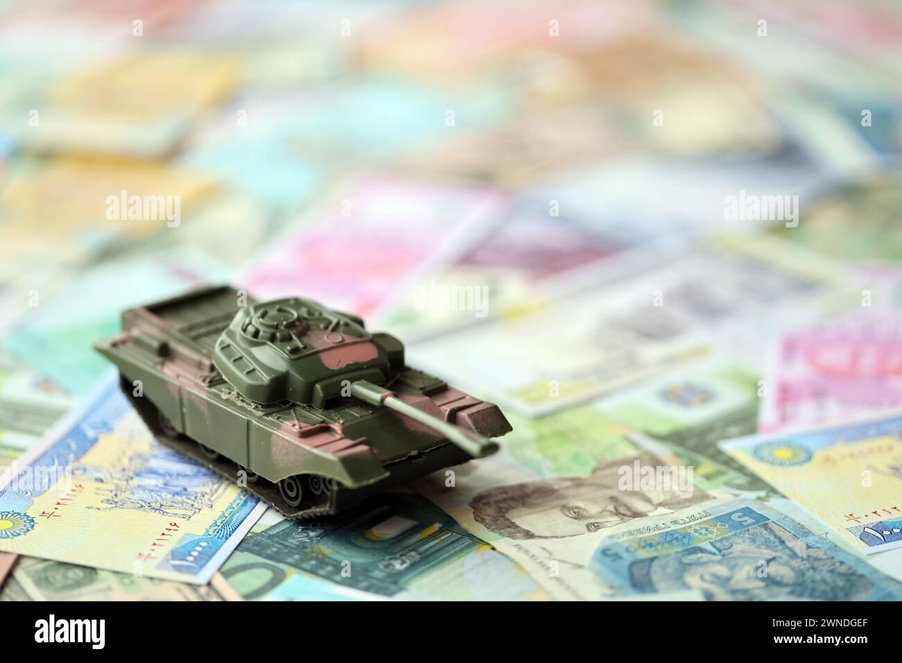 Small green tank on many banknotes of different currency. Background of ...