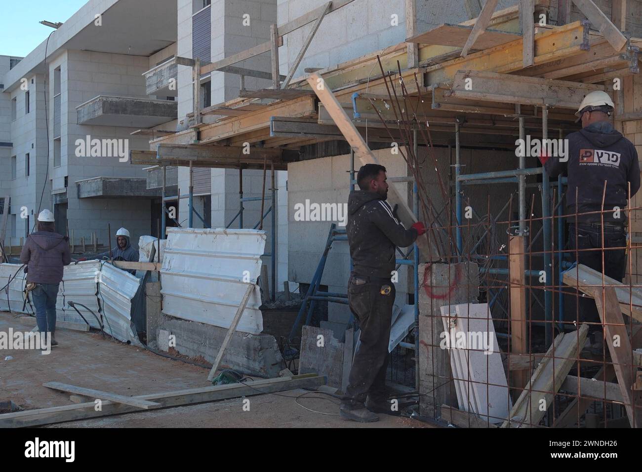 Palestinian laborers work at a construction site of a new housing ...