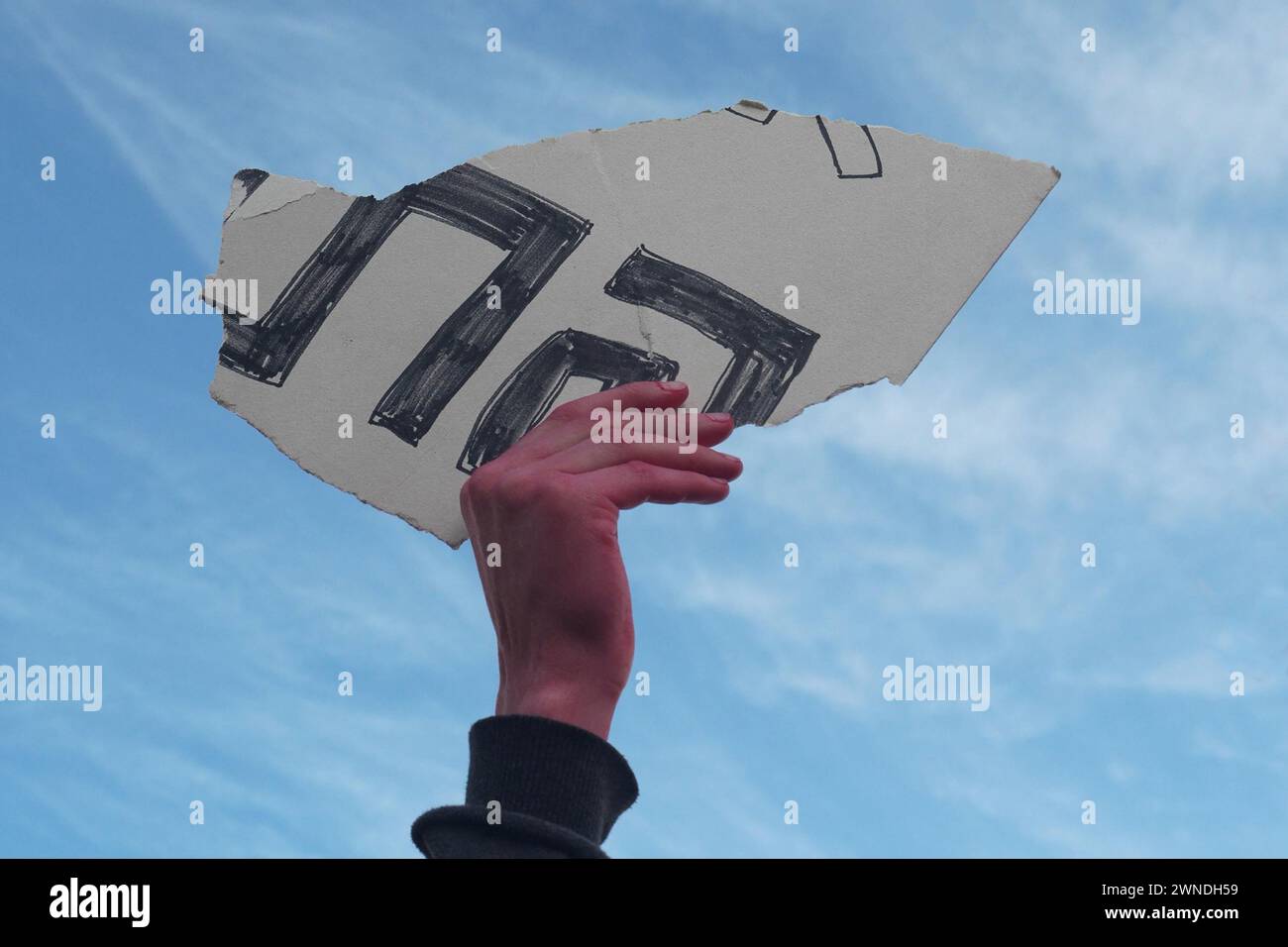 An Israeli peace activist holds up a torn sign that was torn down by ...