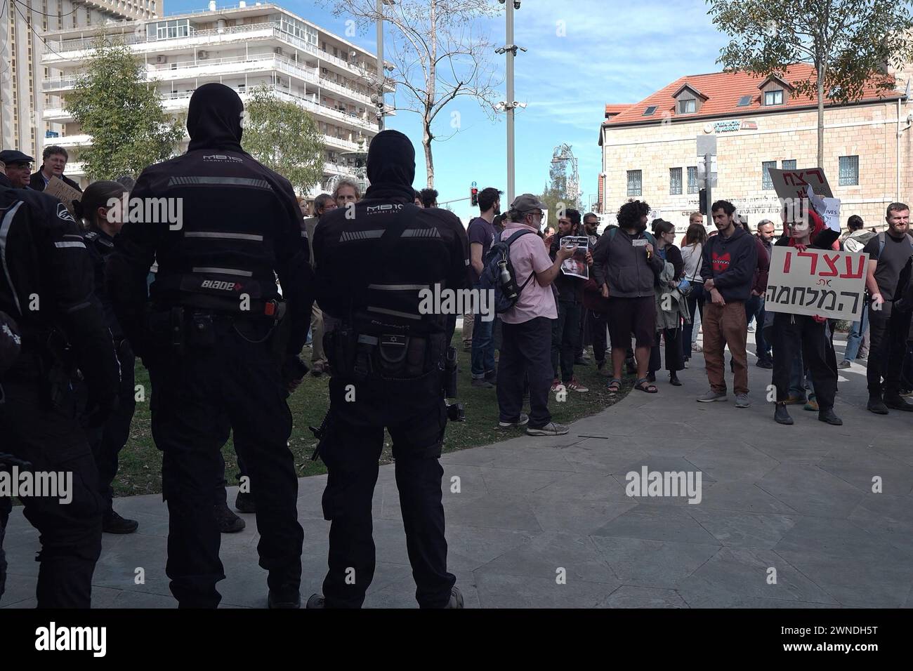 Police officers watch over as Israeli peace activists hold signs during ...