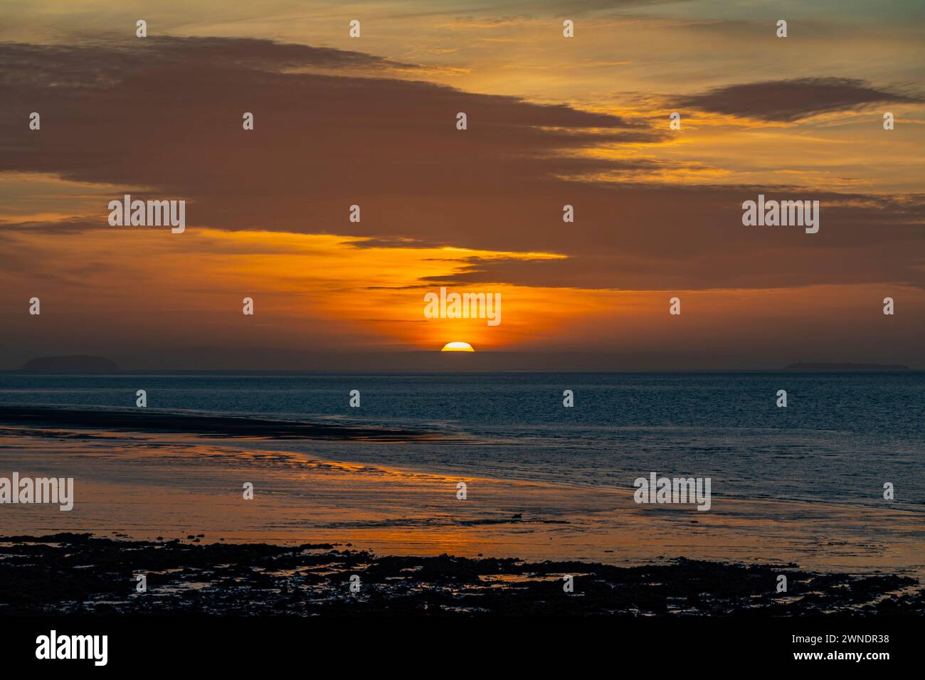 The setting sun lighting up the cloud cover Stock Photo - Alamy