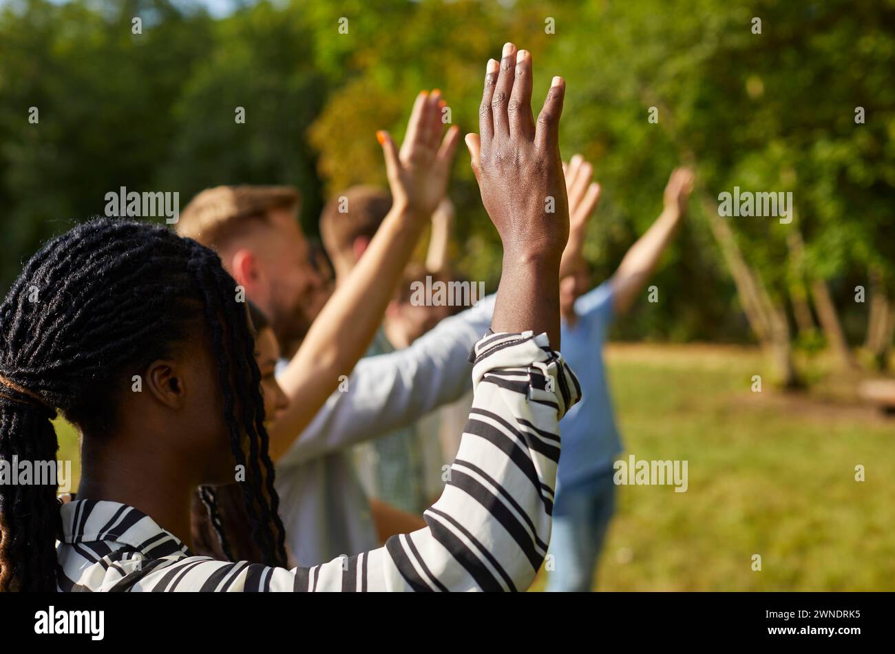 Diverse audience raising hands to ask questions at educational event in ...