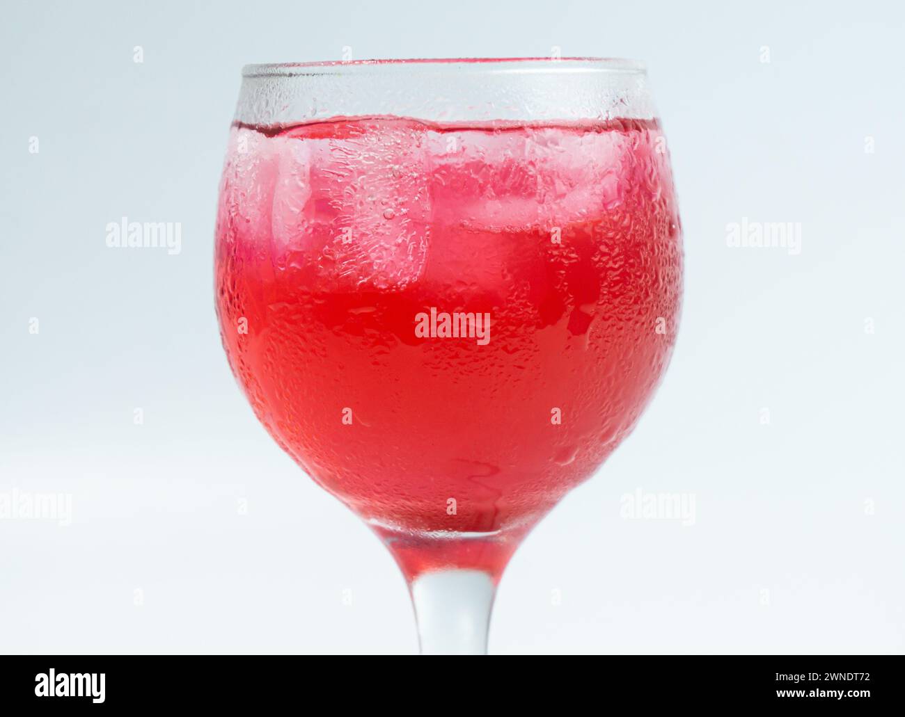 Raspberry or frambozen flavored red syrup in glass cup isolated on ...
