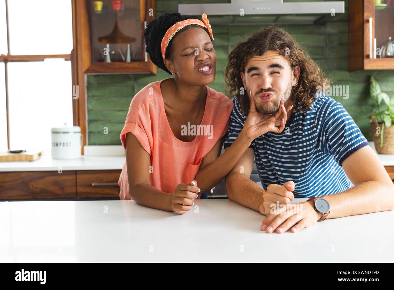 Diverse couple young African American woman playfully pinches the cheek ...