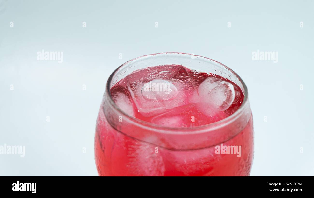 Raspberry or frambozen flavored red syrup in glass cup isolated on ...