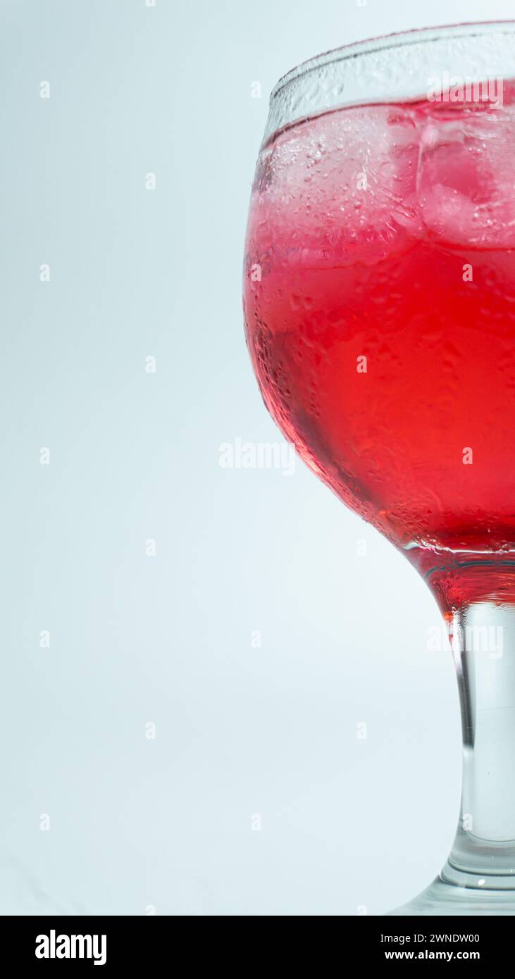 Raspberry or frambozen flavored red syrup in glass cup isolated on ...
