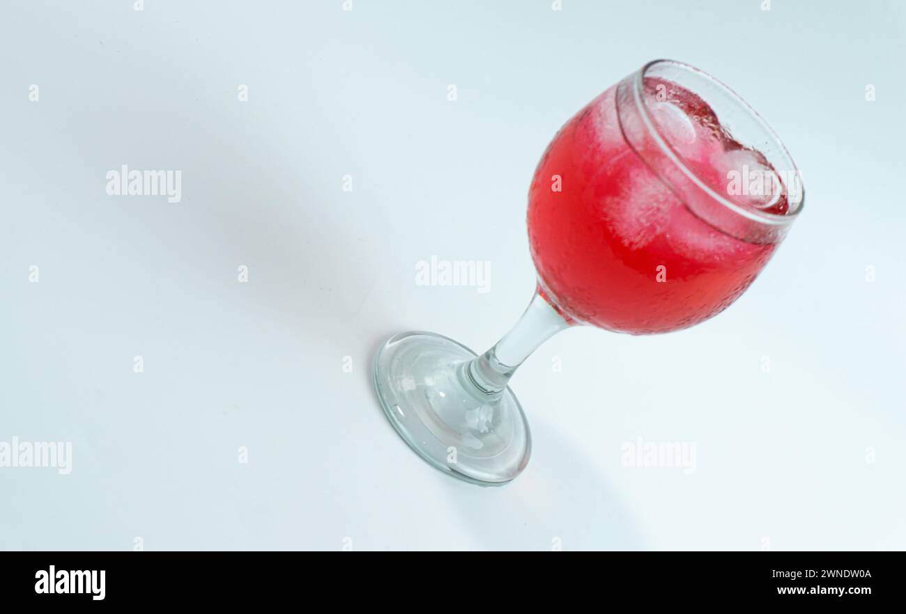 Raspberry or frambozen flavored red syrup in glass cup isolated on ...