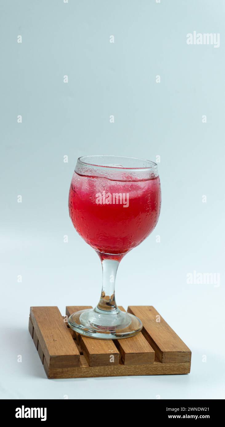 Raspberry or frambozen flavored red syrup in glass cup isolated on ...