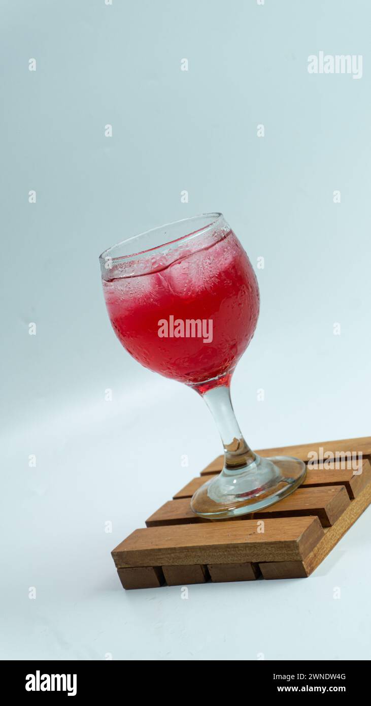 Raspberry or frambozen flavored red syrup in glass cup isolated on ...