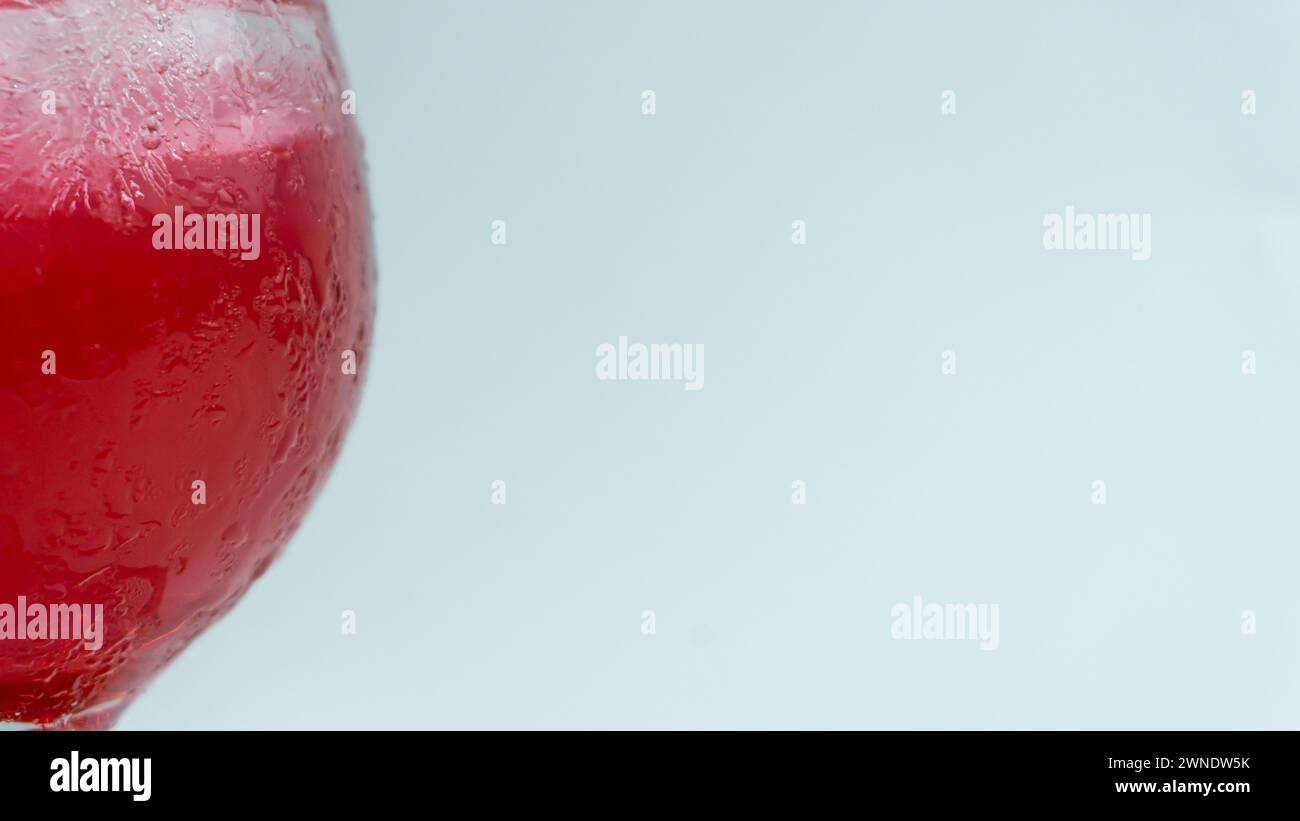 Raspberry or frambozen flavored red syrup in glass cup isolated on ...