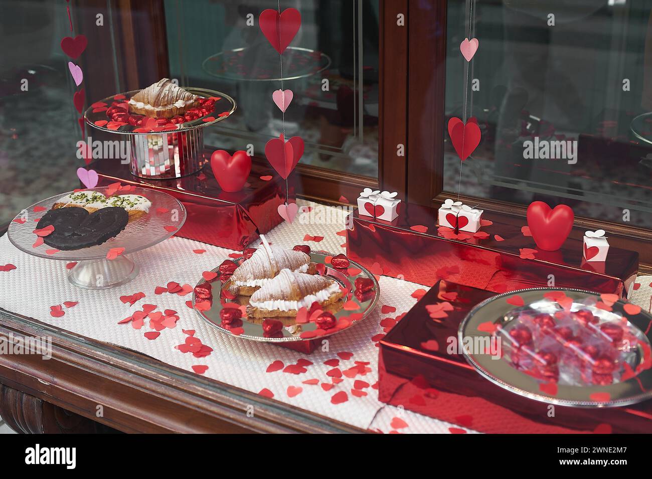 Display case adorned with hearts, displaying Valentine's themed sweets ...