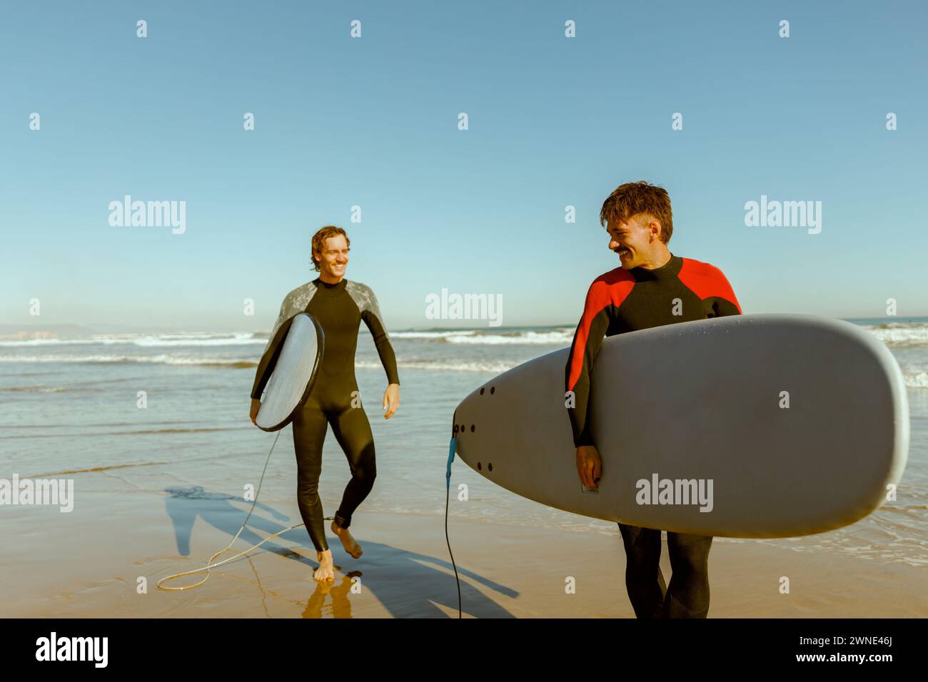 Group of surfers with surfboards in wetsuit are walking on the beach ...