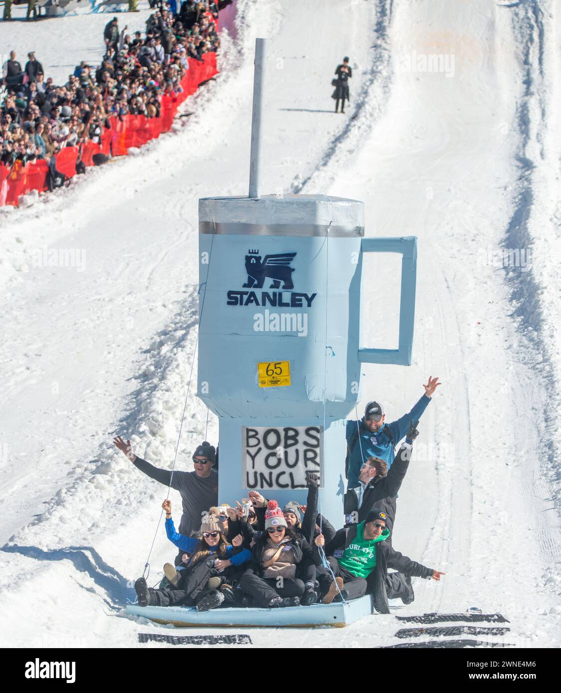 Participants react after sledding down the mountain in their Stanley ...