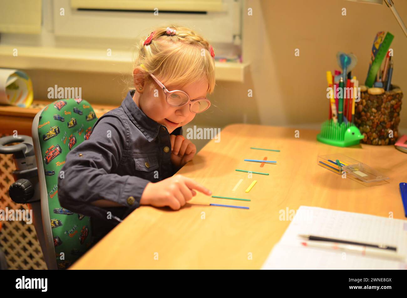 A girl learns to count using counting sticks for children by studying ...