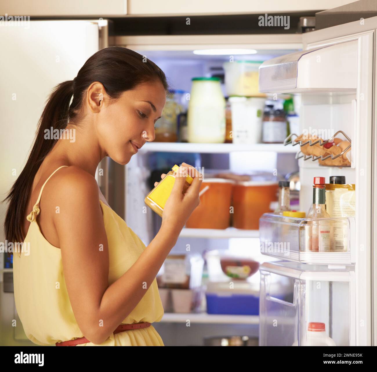 Fridge, cooking and woman with sauce in kitchen checking nutrition ...
