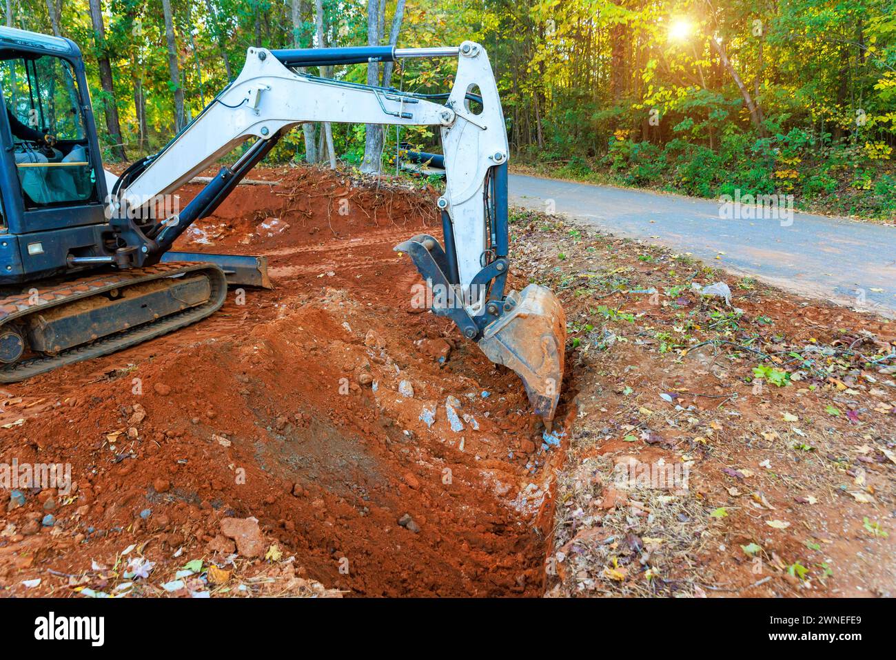 During construction of collection system, an excavator digs trench in ...