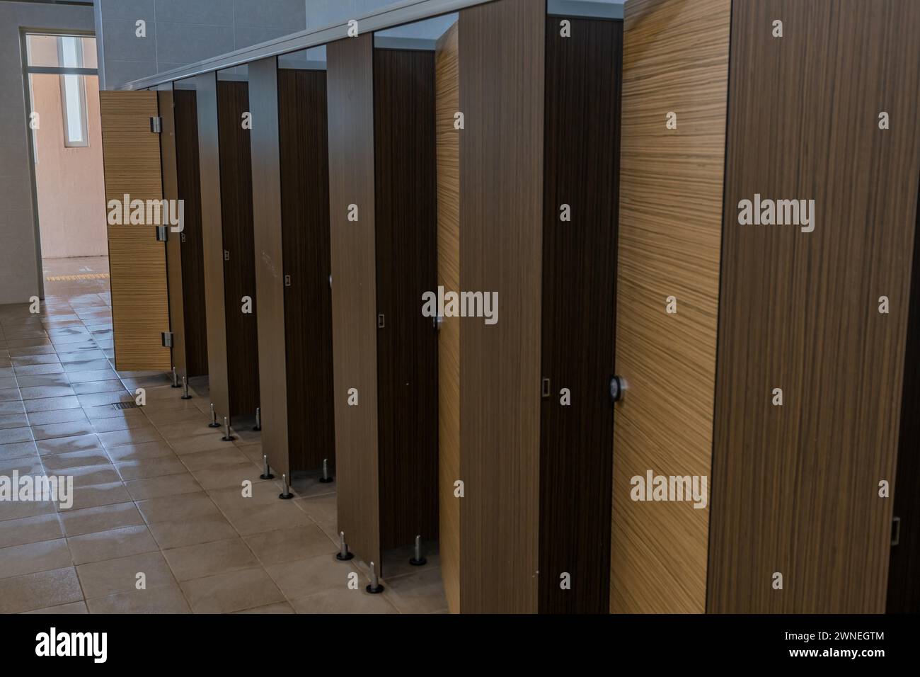 Wood grain doors to toilet stalls in men's public restroom in South ...