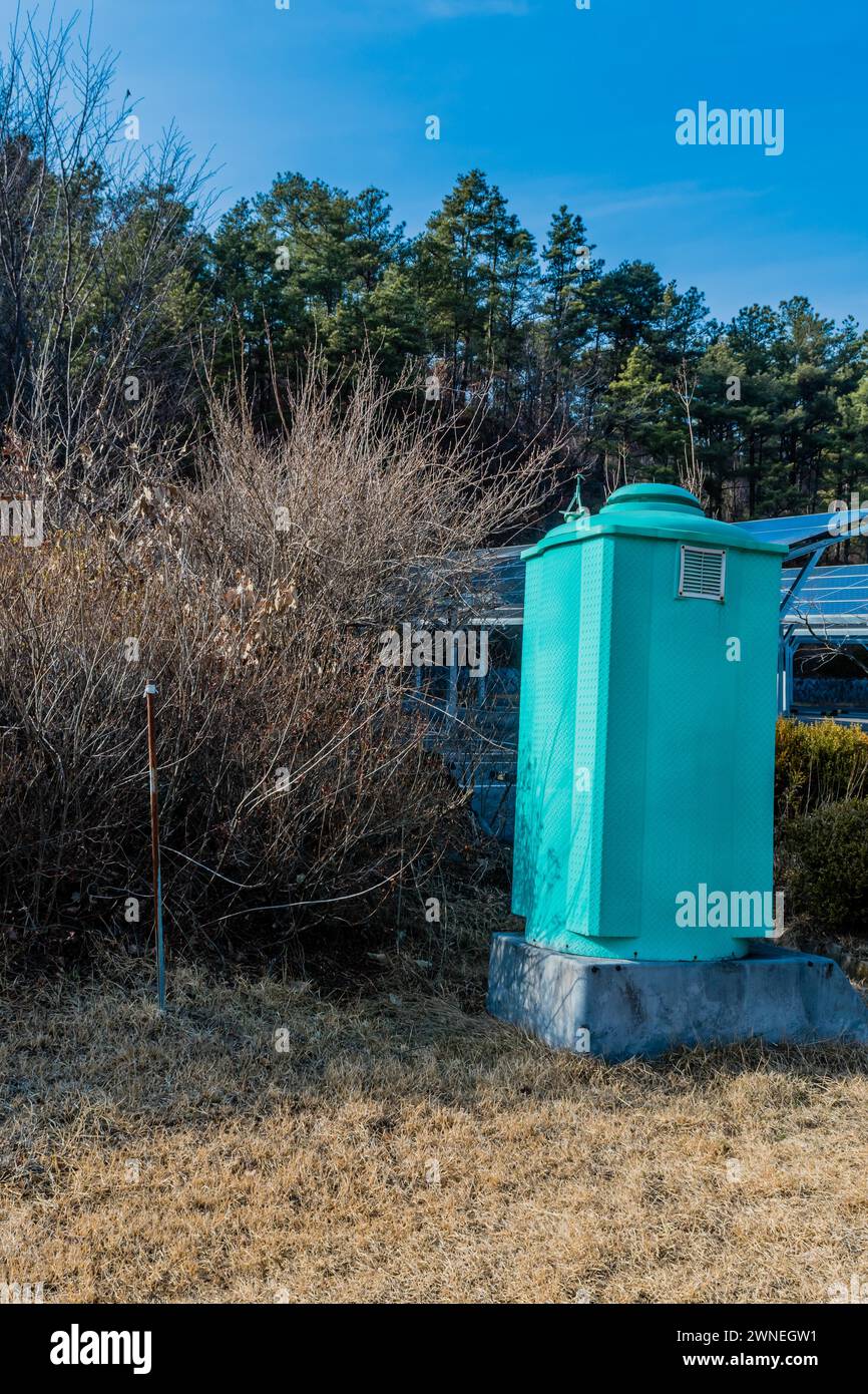 Rear view of old green plastic public toilet in wilderness park in ...