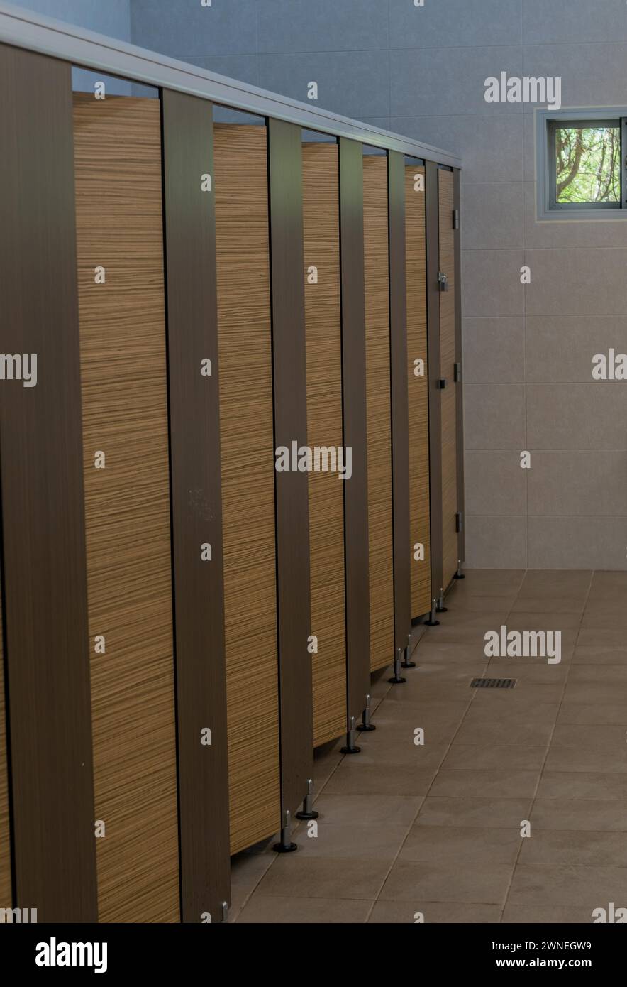 Wood grain doors to toilet stalls in men's public restroom in South ...