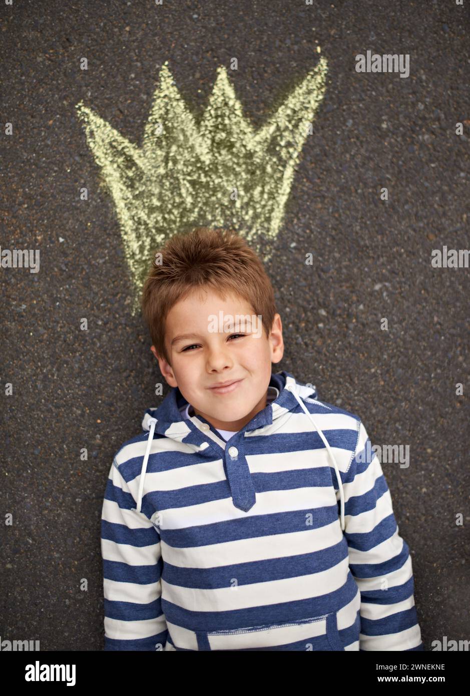 Chalk art, portrait and boy with crown on floor for drawing, imagine or ...