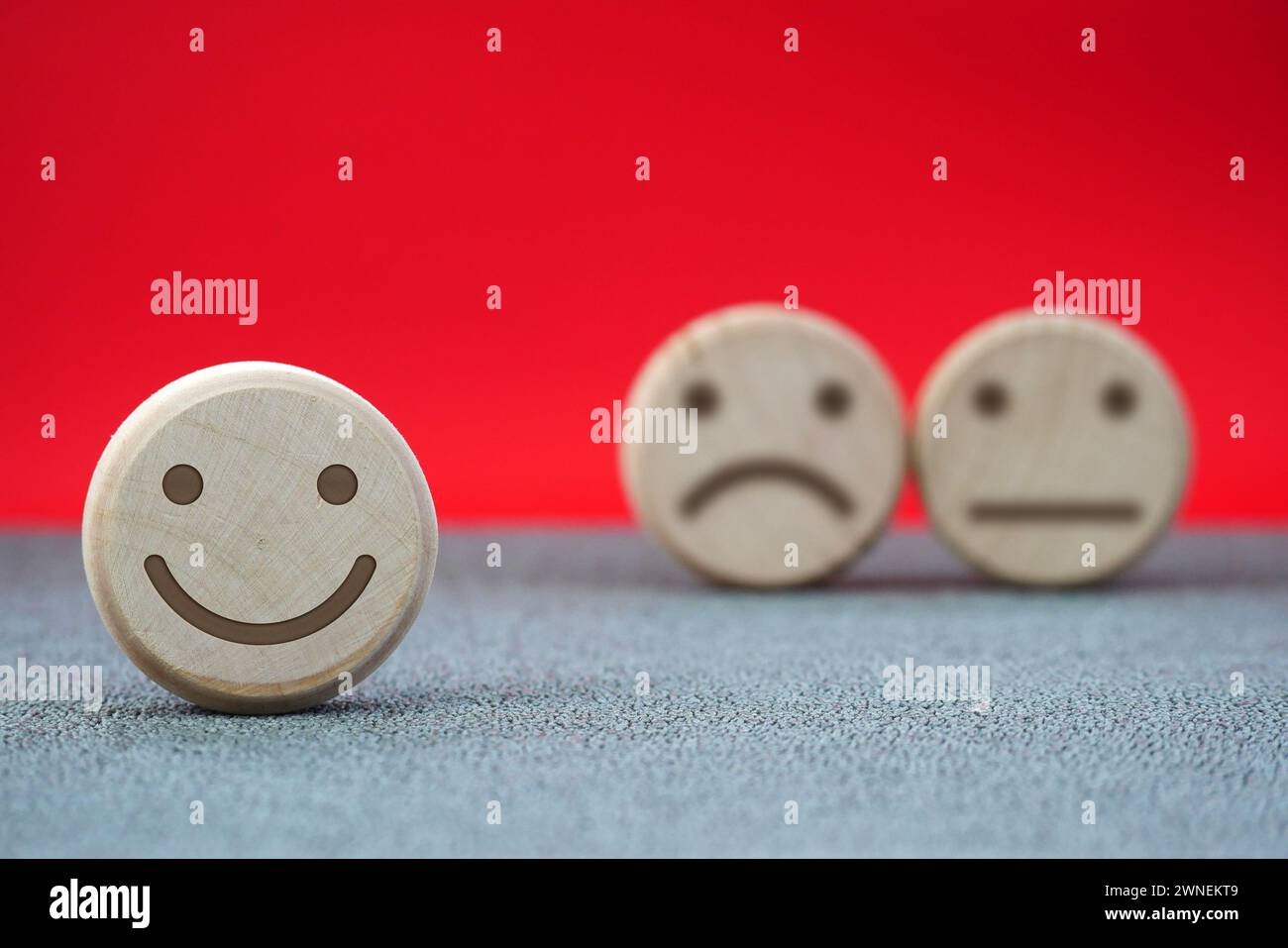 Wooden round with carved happy and angry faces, International Day of ...