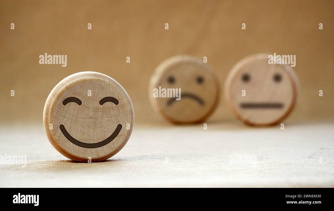 Wooden round with carved happy and angry faces, International Day of ...