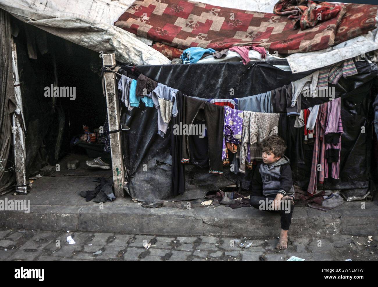 Rafah, Gaza. 29th Feb, 2024. A displaced Palestinian child sits outside ...