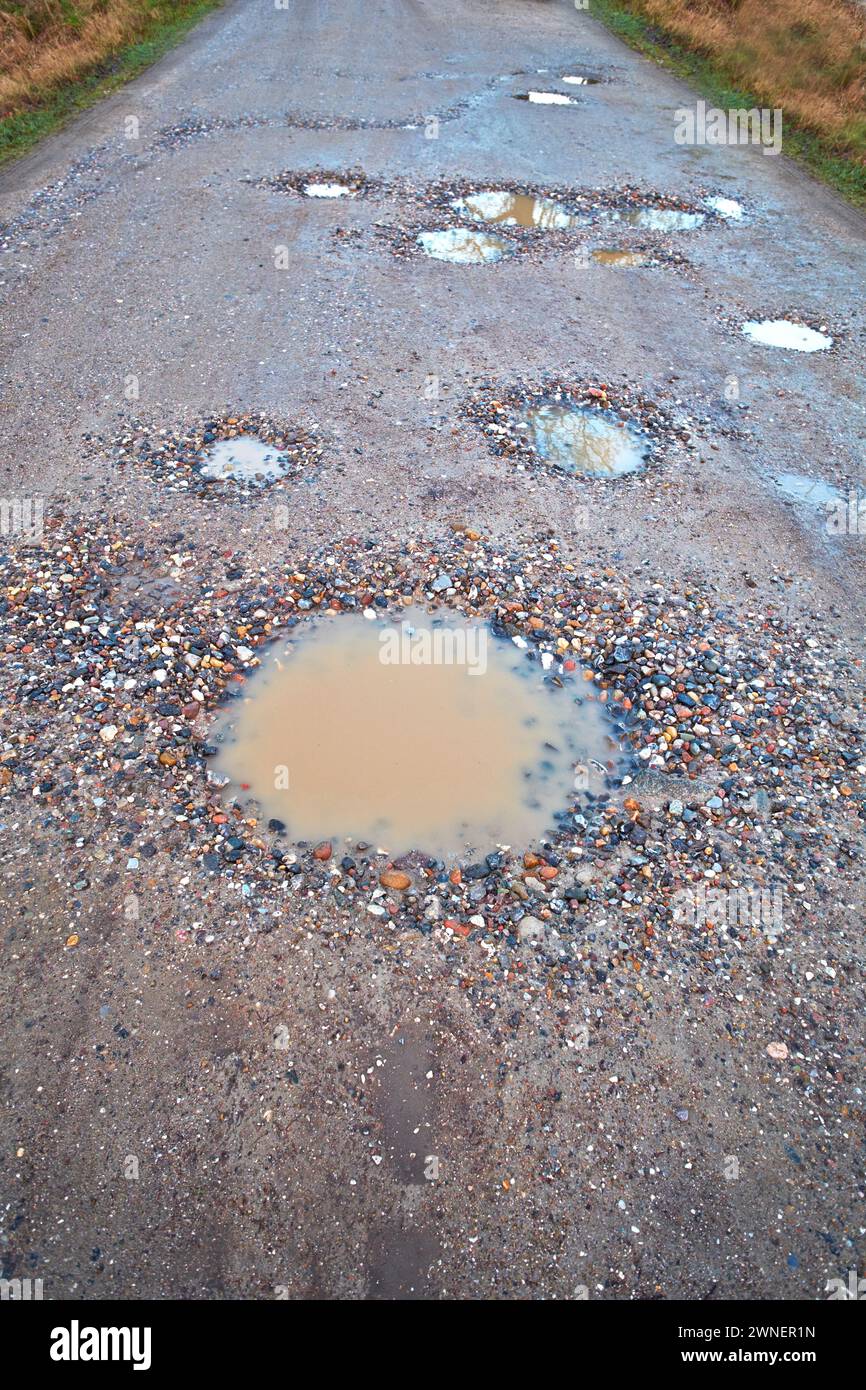Water, gravel and rural road with pothole with maintenance ...