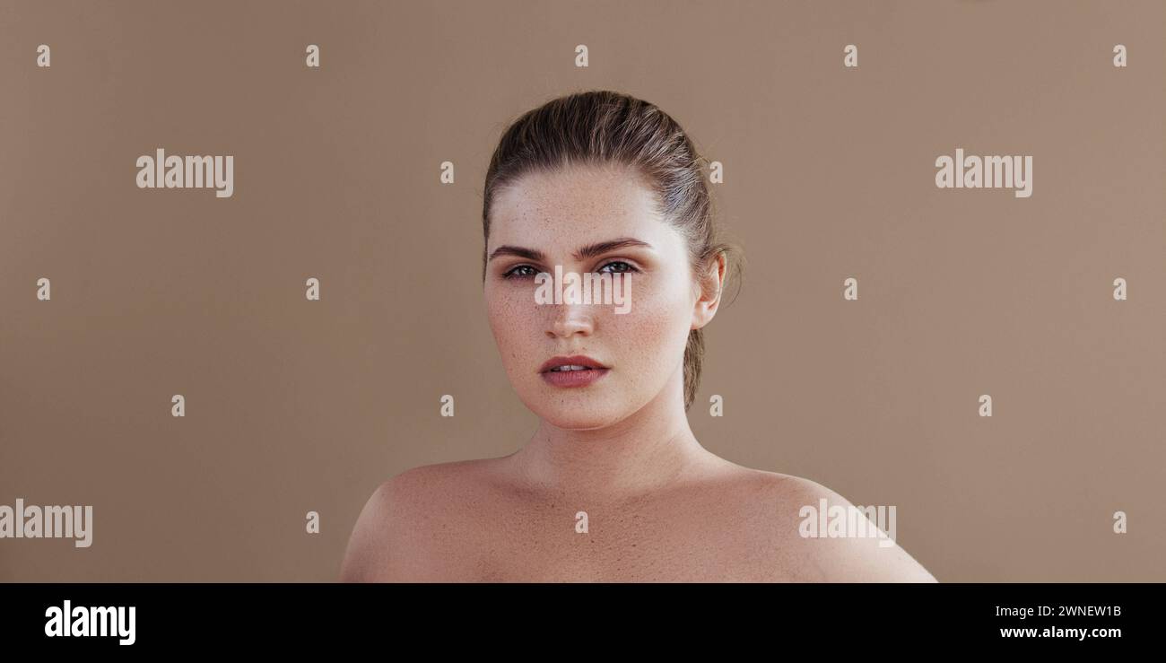 Portrait of a plus size woman posing over pastel backdrop. Young female ...