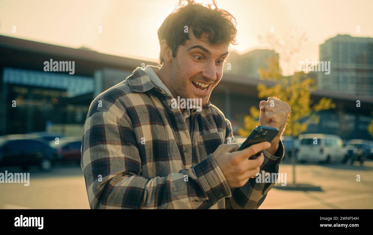 Happy excited successful Caucasian man guy walking use smartphone ...