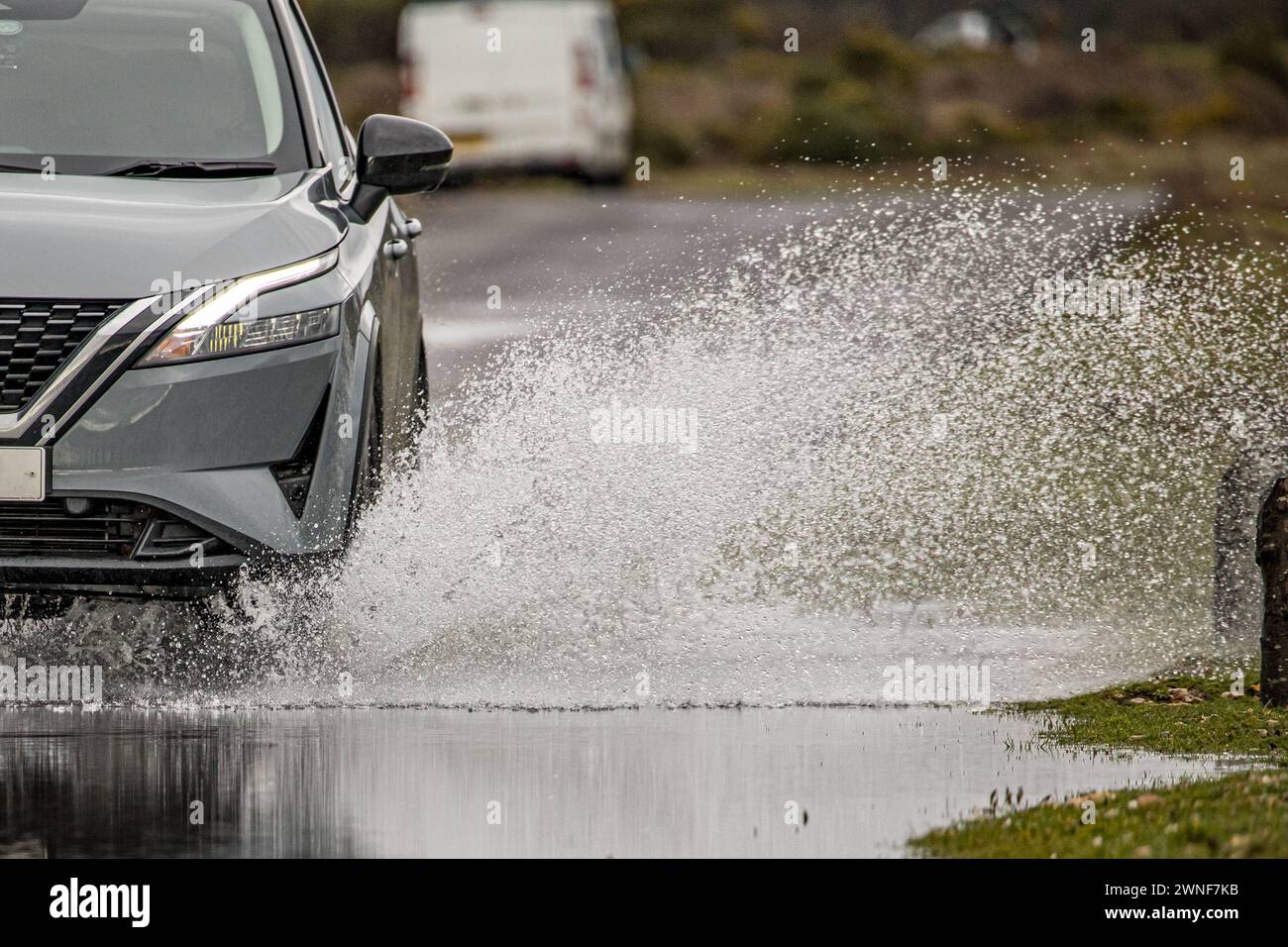 Water spray from a car wheel and the front section of the car as it ...