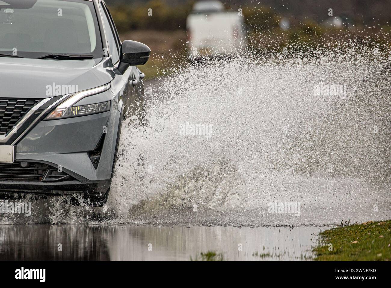 Water spray from a car wheel and the front section of the car as it ...